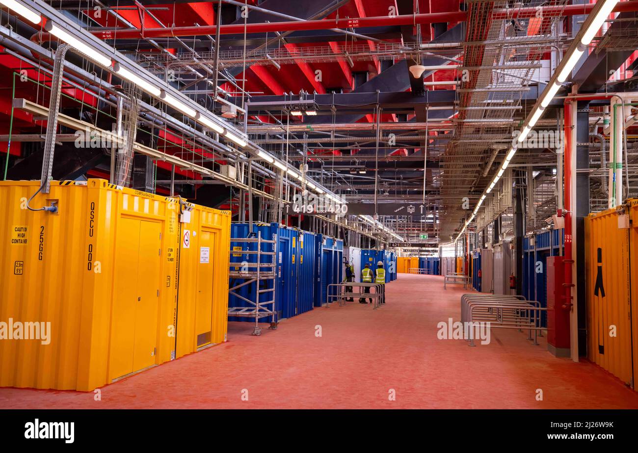 Doha, Qatar. 30th Mar, 2022. Workers stand in a hallway at Stadium 974 ...