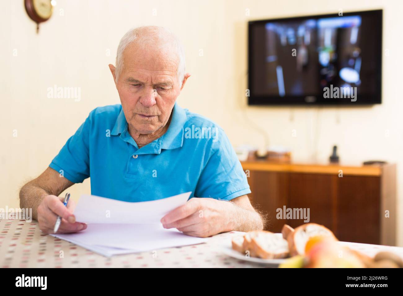 Elderly man signing papers hi-res stock photography and images - Alamy