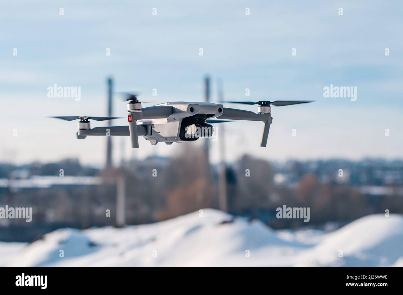 Modern gray drone in flight over city. New technology. Blurred ...