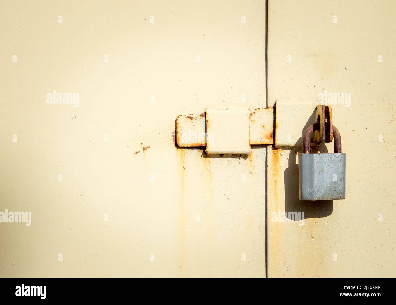 Rusty padlock with locked gray metal door texture background with space ...
