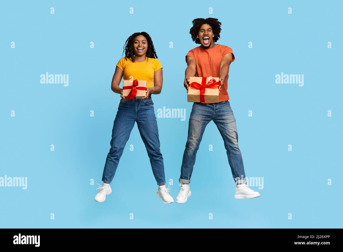 Cheerful african american couple showing their gifts Stock Photo - Alamy
