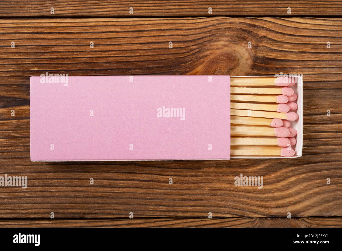 top view pink color matchbox with pink match sticks on a wood table ...