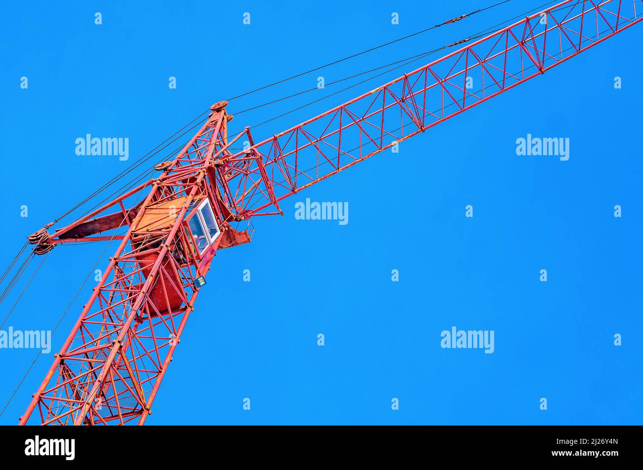 Construction crane on background of blue sky. Crane driver's cab close ...