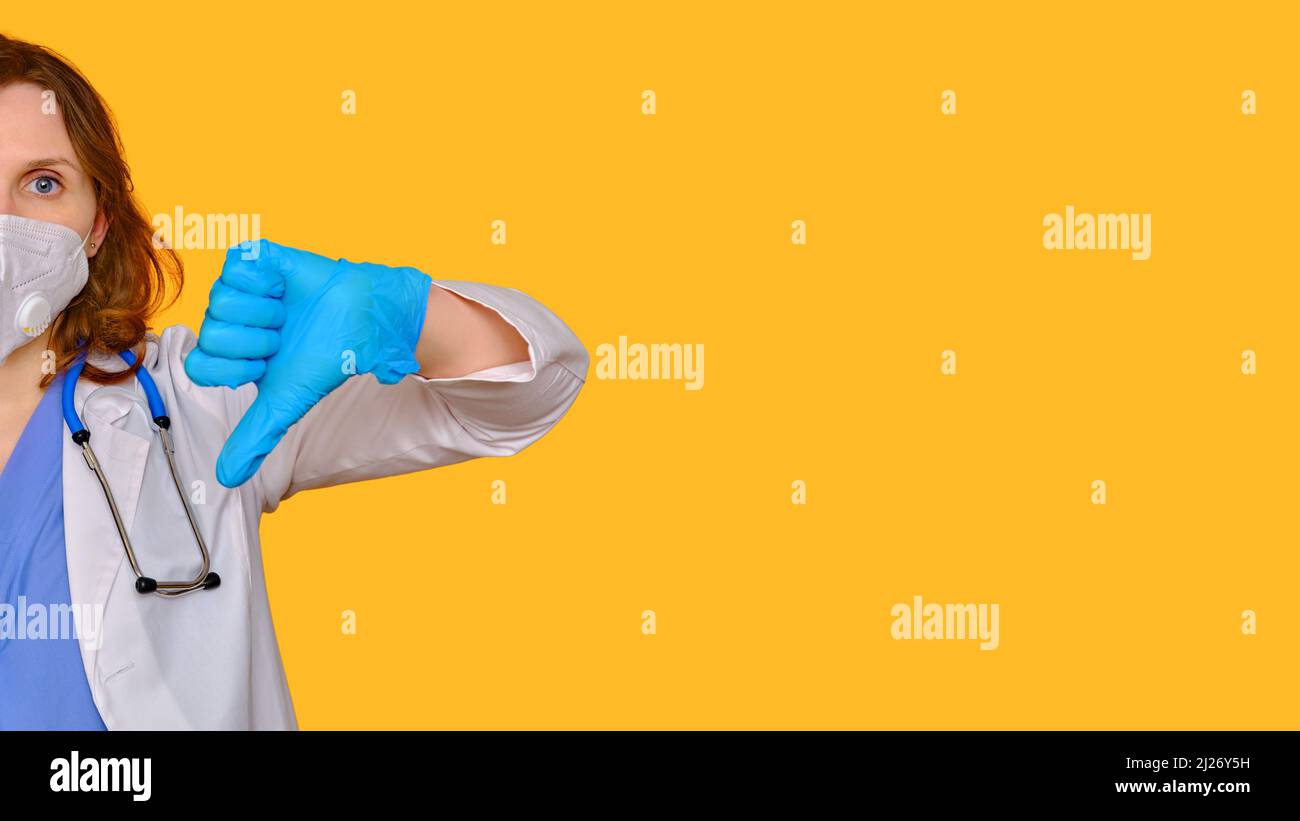 The doctor shows an disapproving gesture - thumb down. Female nurse on ...