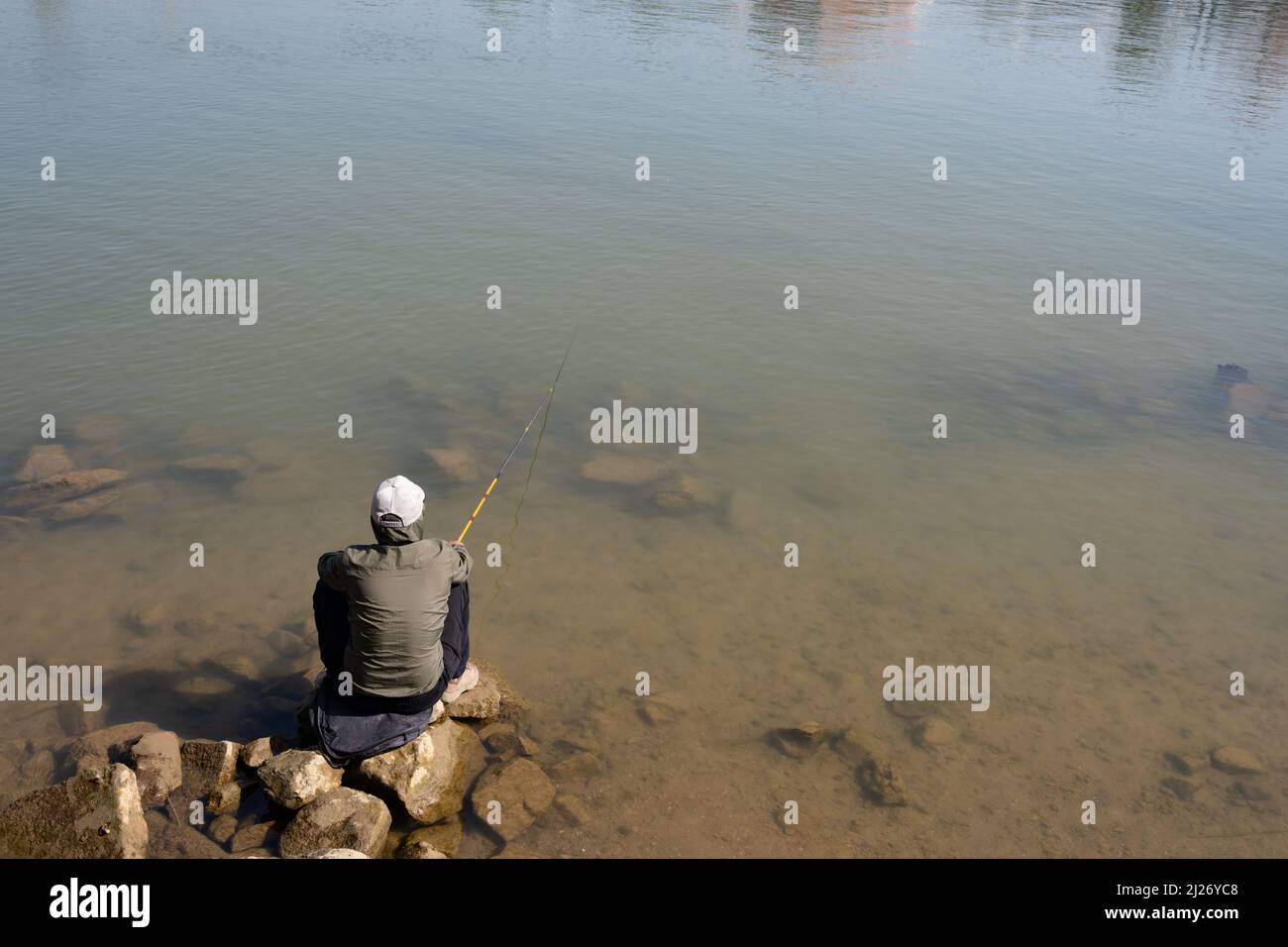 lady fishing on the edge of a river Stock Photo - Alamy