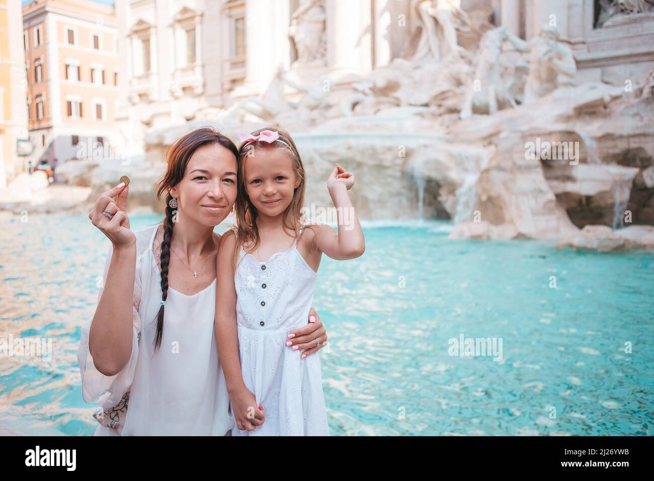 Travel family mom and girl trowing coin at Trevi Fountain, Rome, Italy ...
