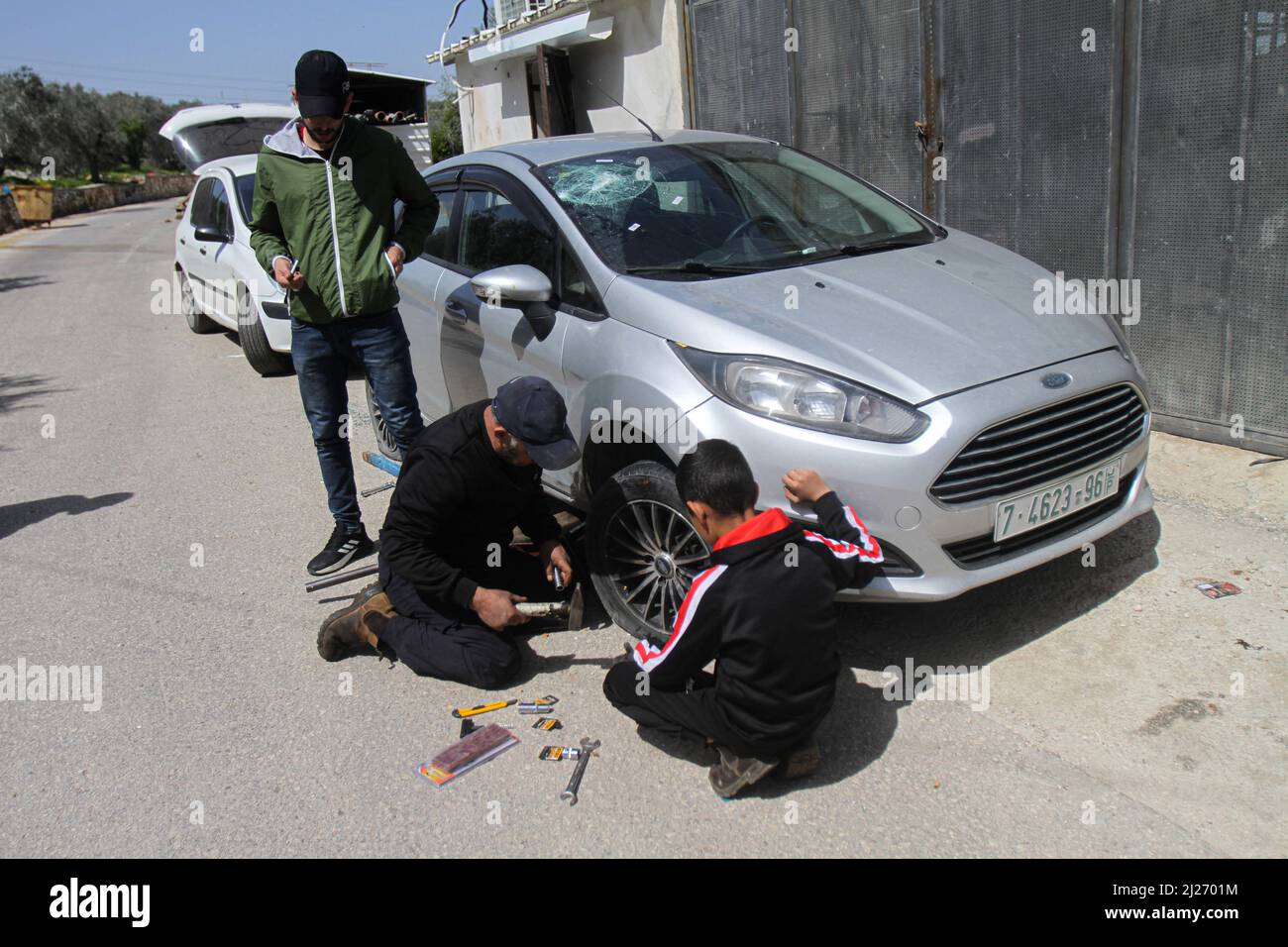 Palestinians inspect their destroyed car. In the late hours of the ...