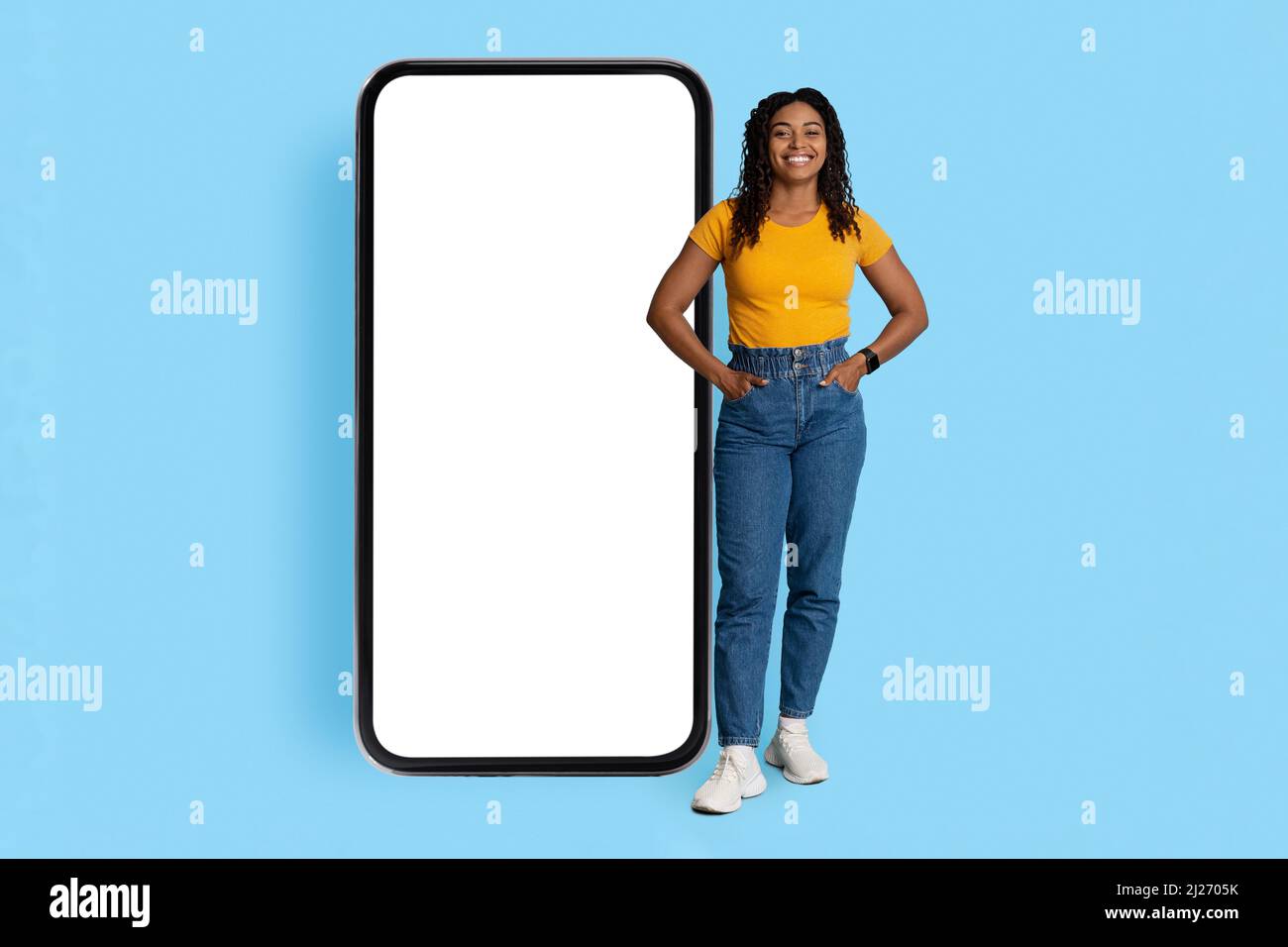 Pretty african american lady posing with smartphone with blank screen ...