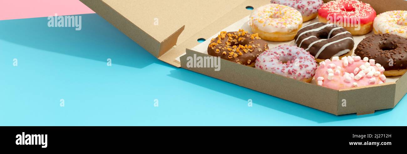 Set of yummy colorful donuts in paper box on blue background Stock ...