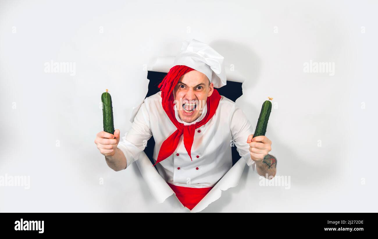 Crazy male cook with vegetables sticking out of hole of white ...