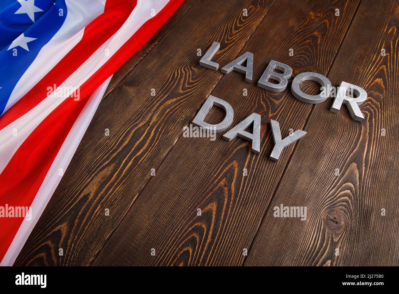 words labor day laid with silver metal letters on wooden surface with ...