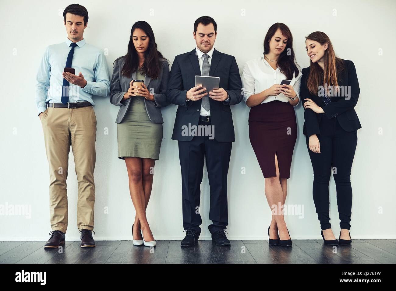 Wireless entertainment while they wait. Studio shot of a group of ...