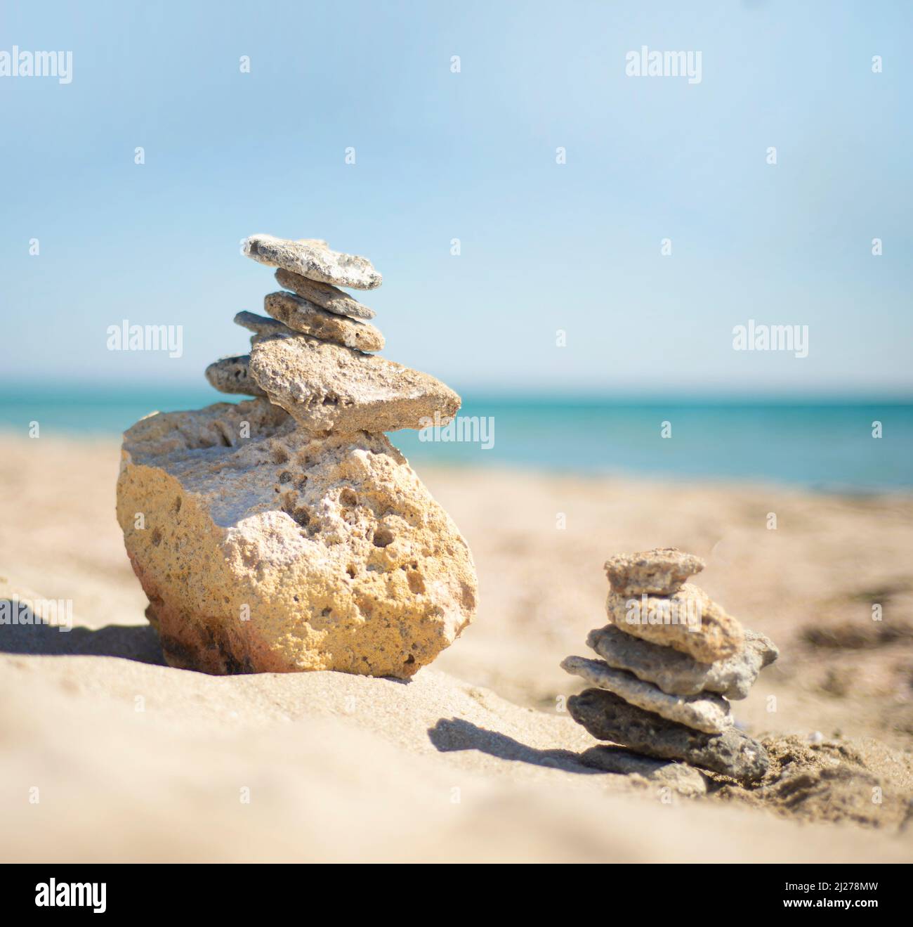 Two pyramids of stones on the seashore. Large and small pyramids on a ...