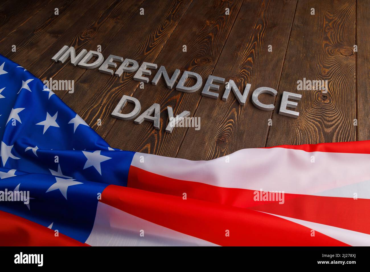 the words independence day laid with real metal letters on brown wooden ...