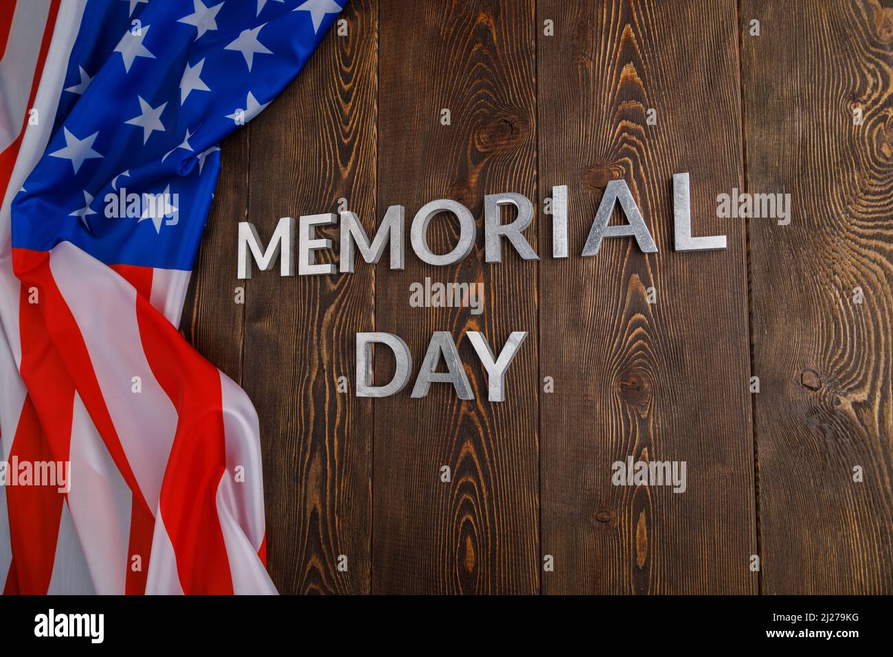 the words memorial day laid with silver metal letters on wooden board ...