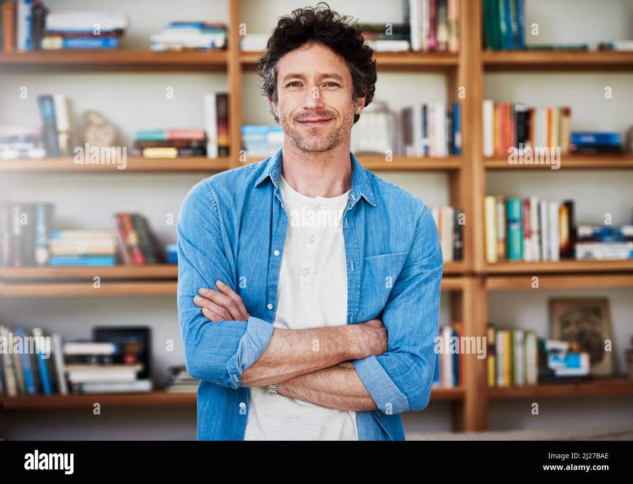 Man standing in front bookshelf hi-res stock photography and images - Alamy