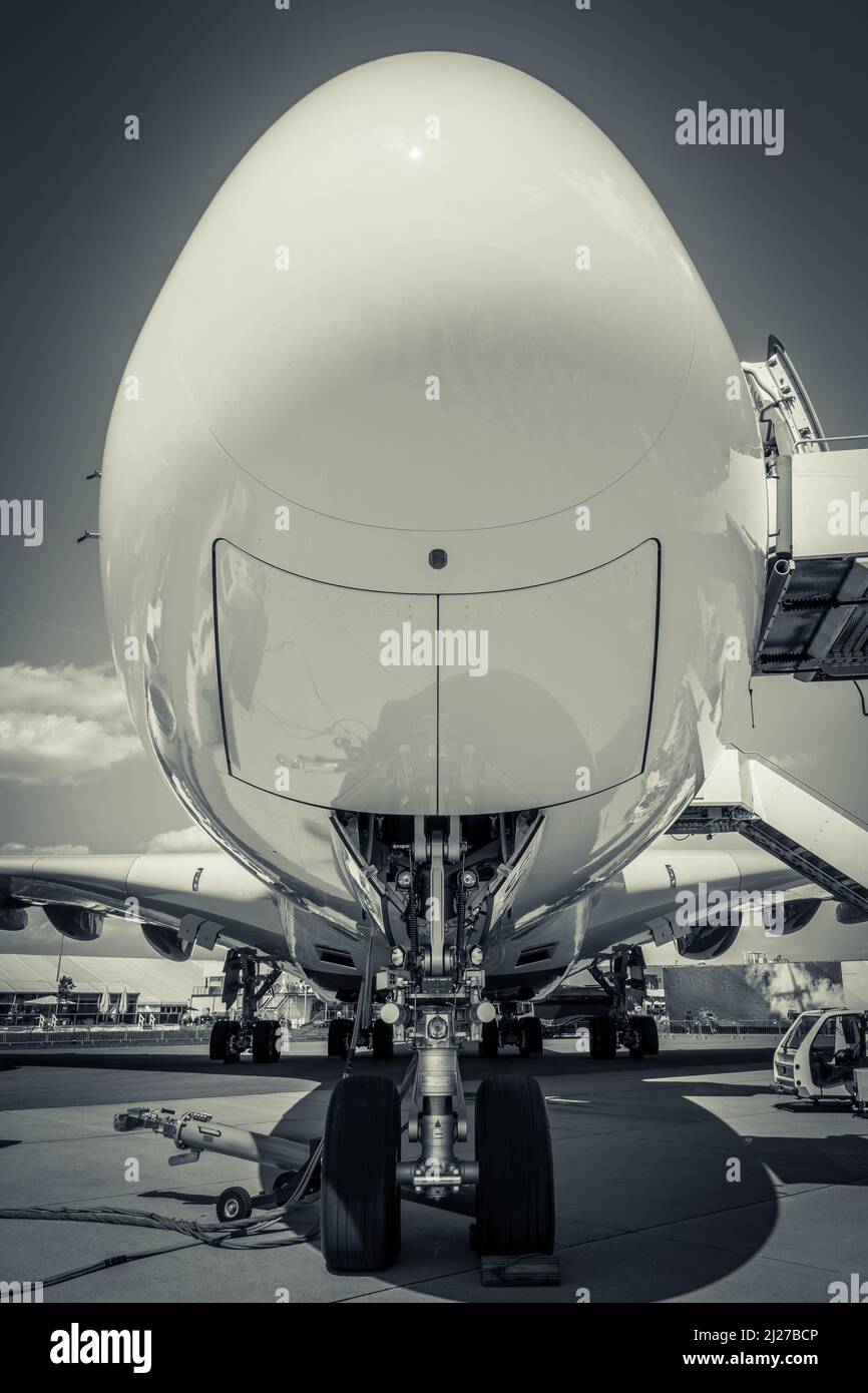 A vertical shot of a plane's front part with its cockpit and doors ...