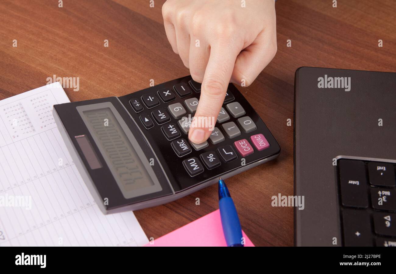 A top view of human working on a computer calculating numbers on a ...