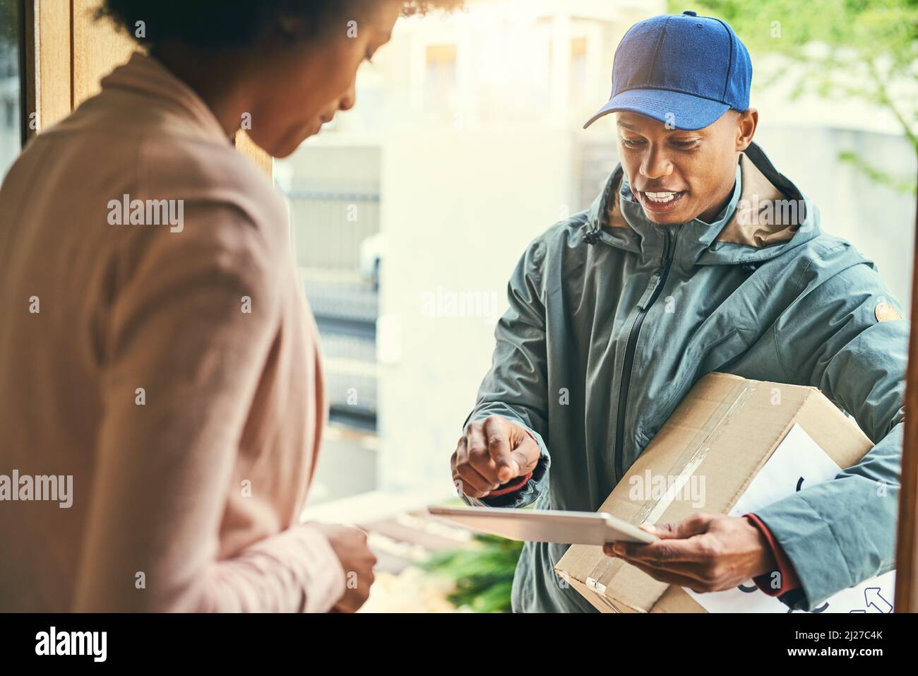 Technology helps us get the job done quicker. Shot of a courier using a ...