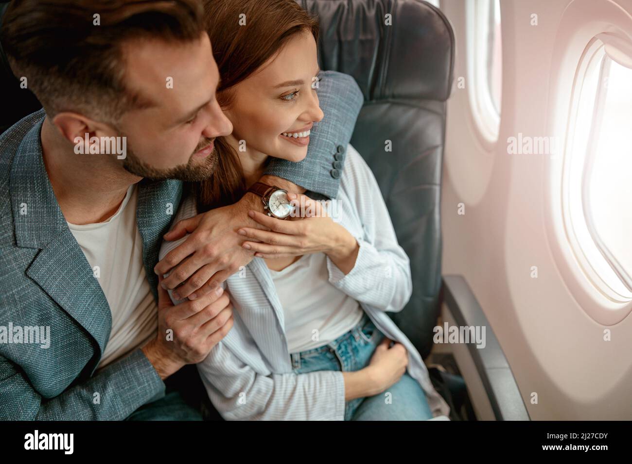 Happy couple in love looking out the window in airplane Stock Photo - Alamy
