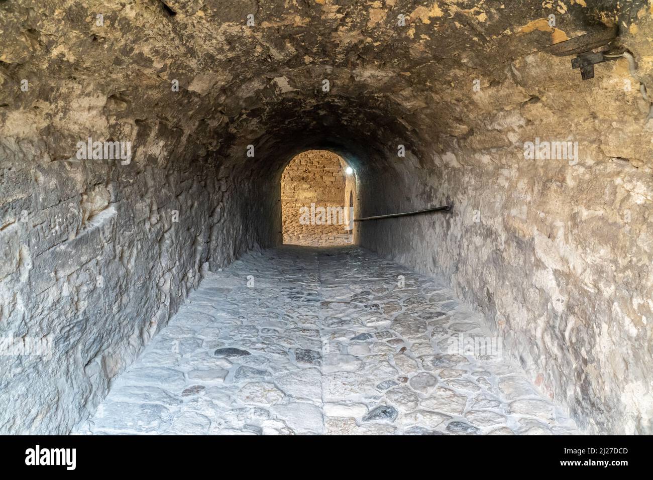 Entrance to a fortress dungeon built with stones and with a woode door ...