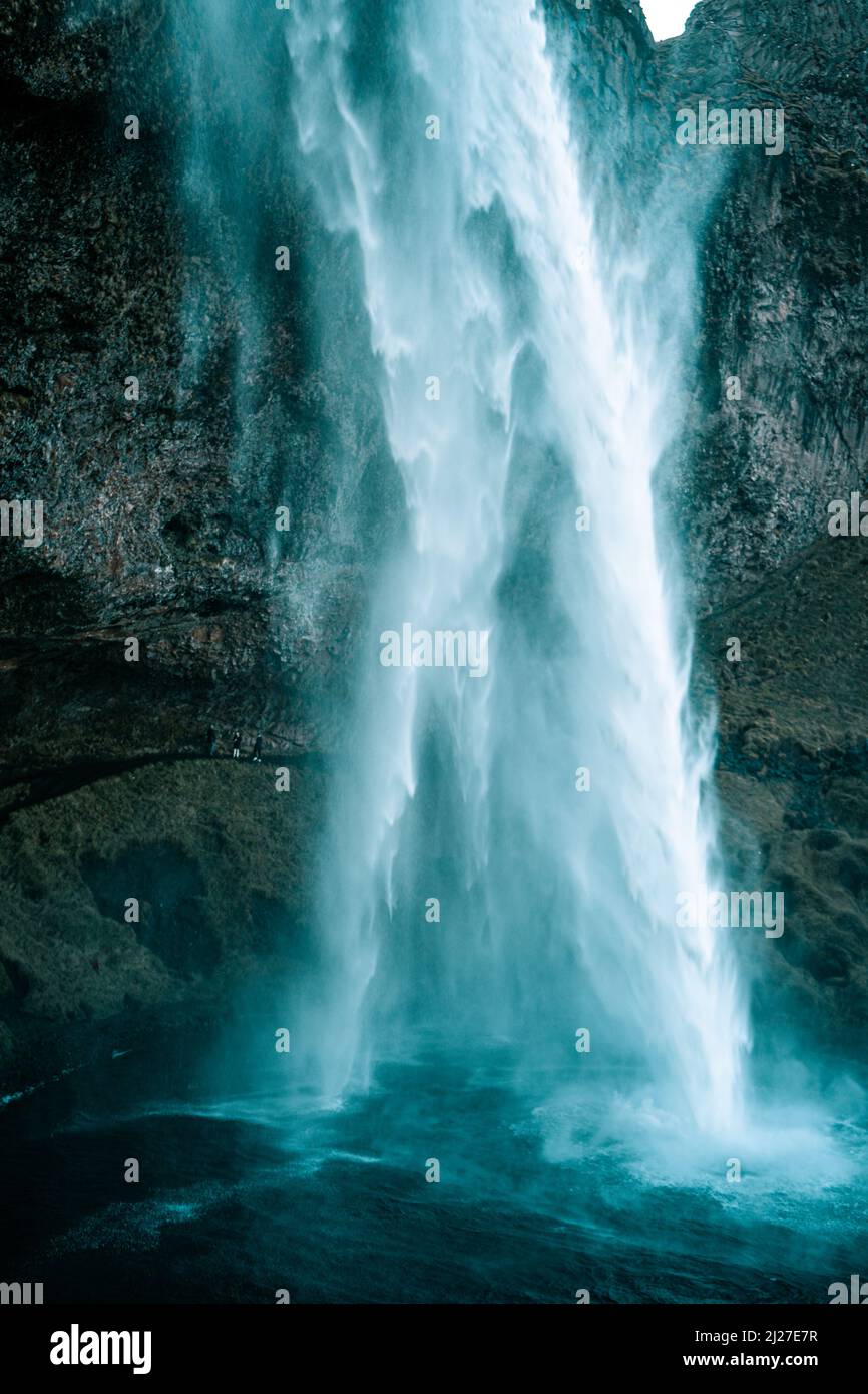 A beautiful vertical shot of the Seljalandsfoss waterfall falling ...