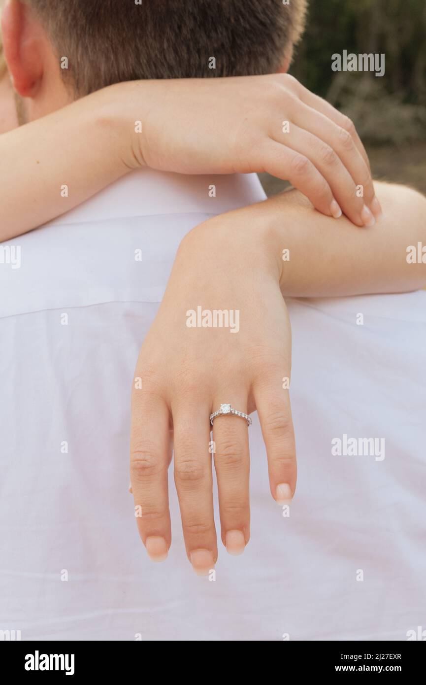 A shot of a couple hugging with a diamond ring on the girl's finger ...