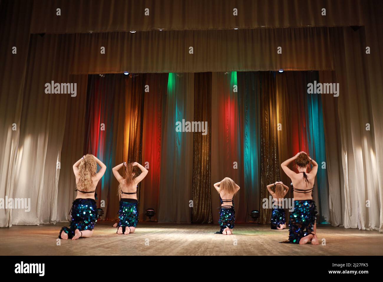 Girls dancers perform on stage with multi-colored lights. Backstage ...