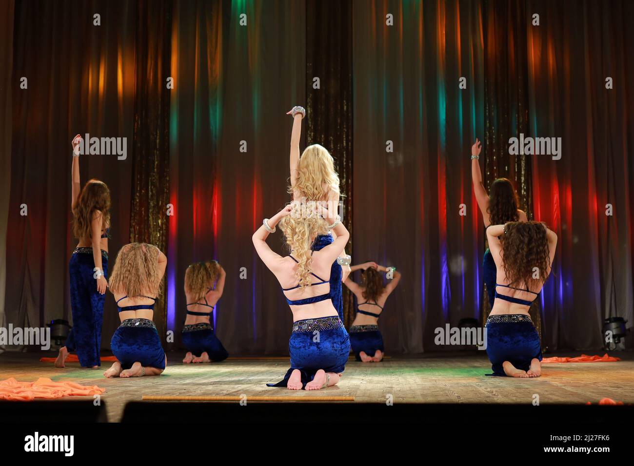 Girls dancers perform on stage with multi-colored lights. Backstage ...
