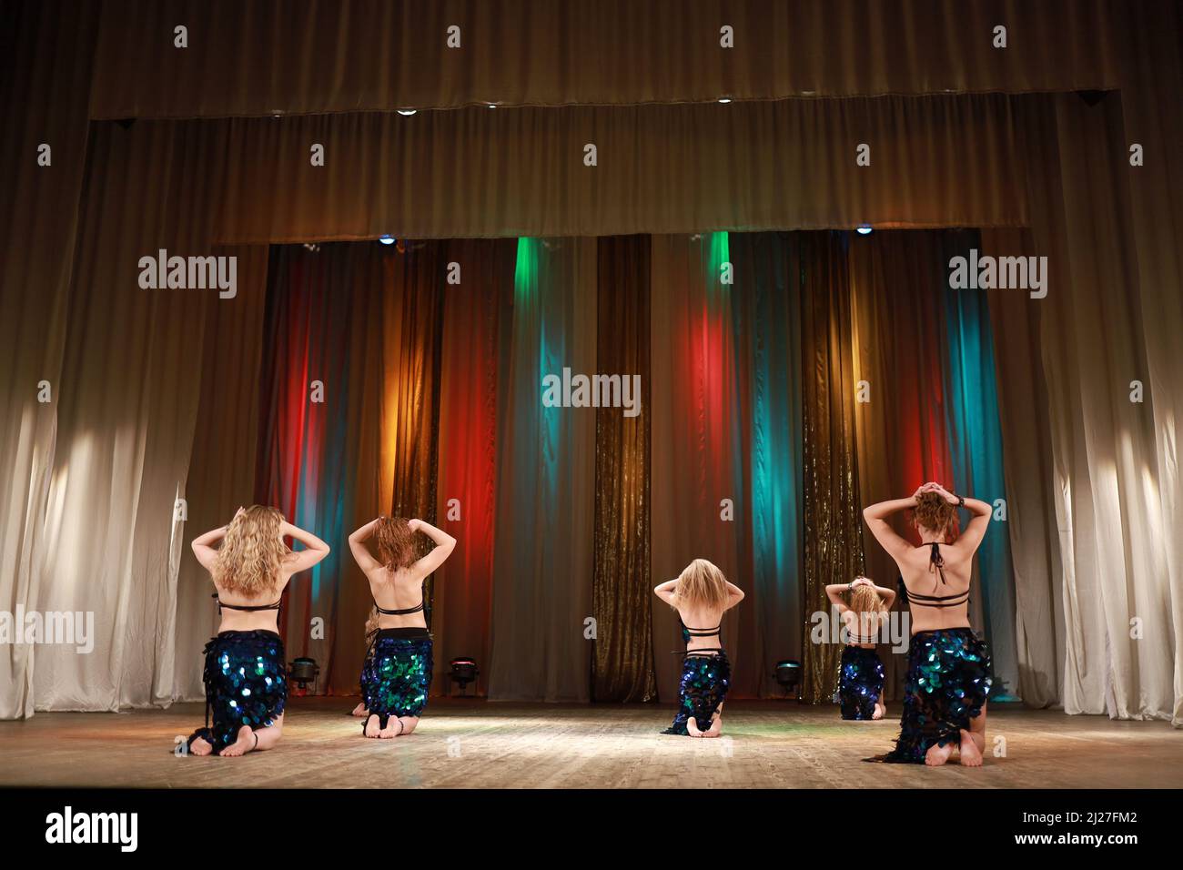 Girls dancers perform on stage with multi-colored lights. Backstage ...