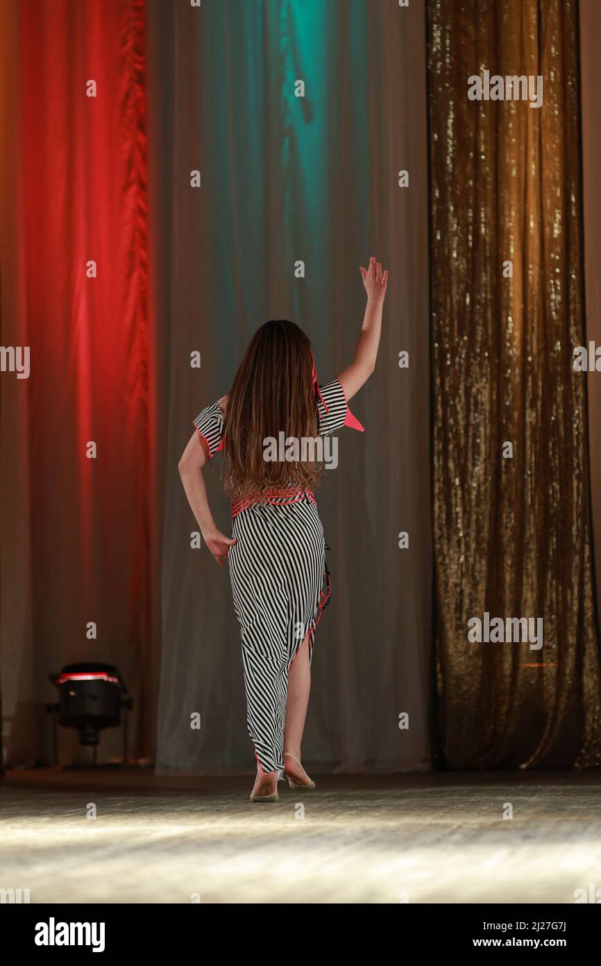 Girls dancers perform on stage with multi-colored lights. Backstage ...