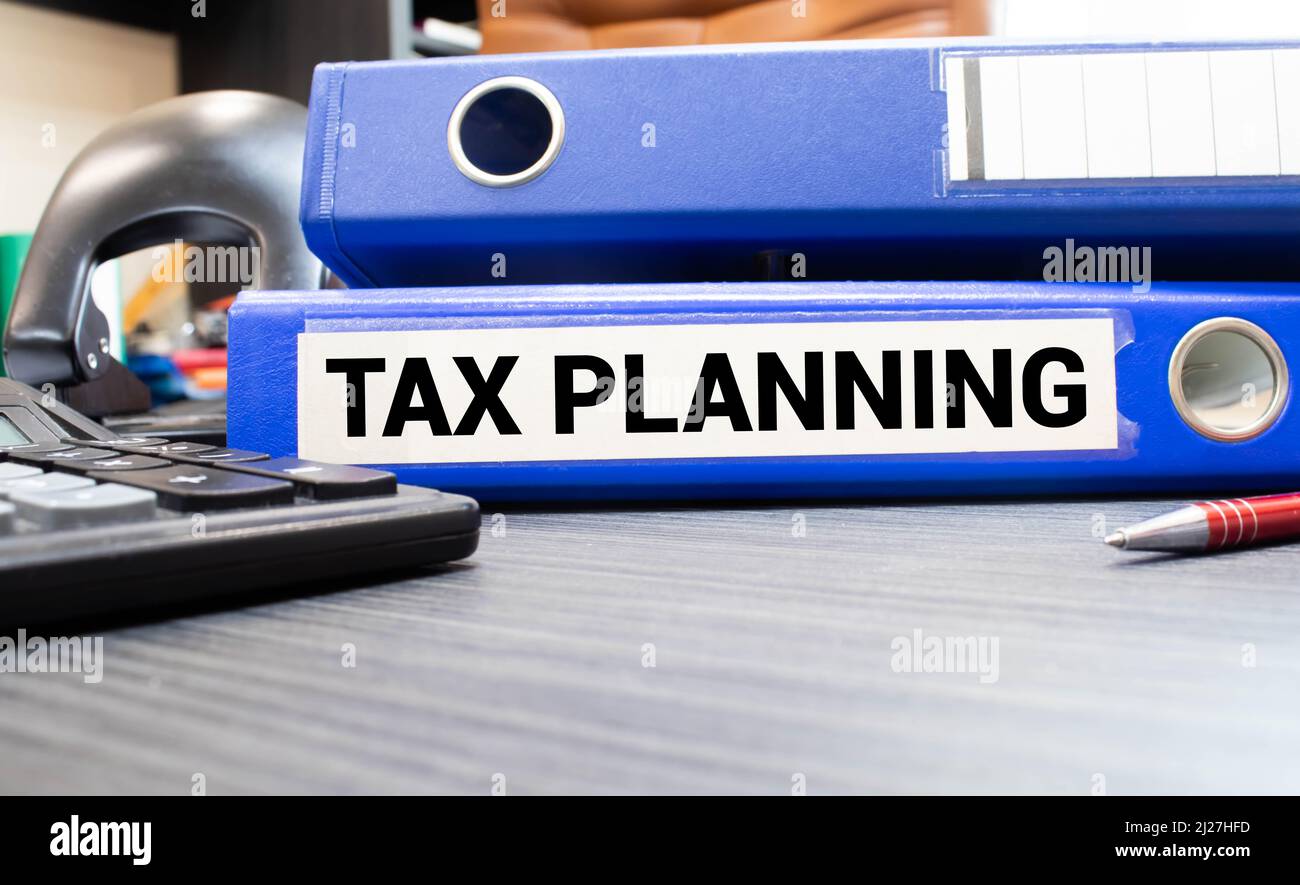 Tax planning book with coins and pen isolated on white Stock Photo - Alamy