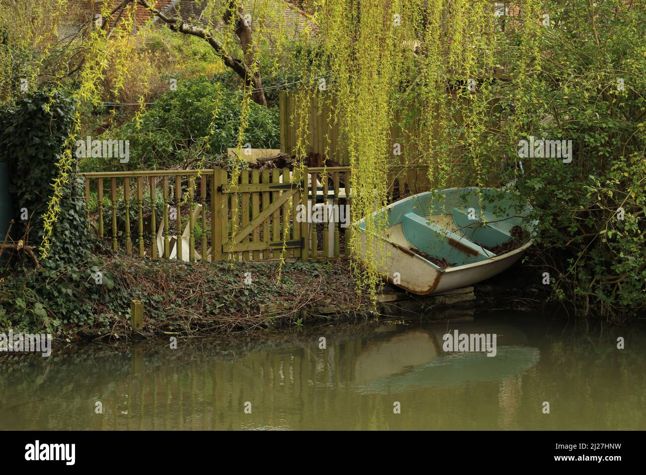 Washed up boat by willow tree Stock Photo - Alamy