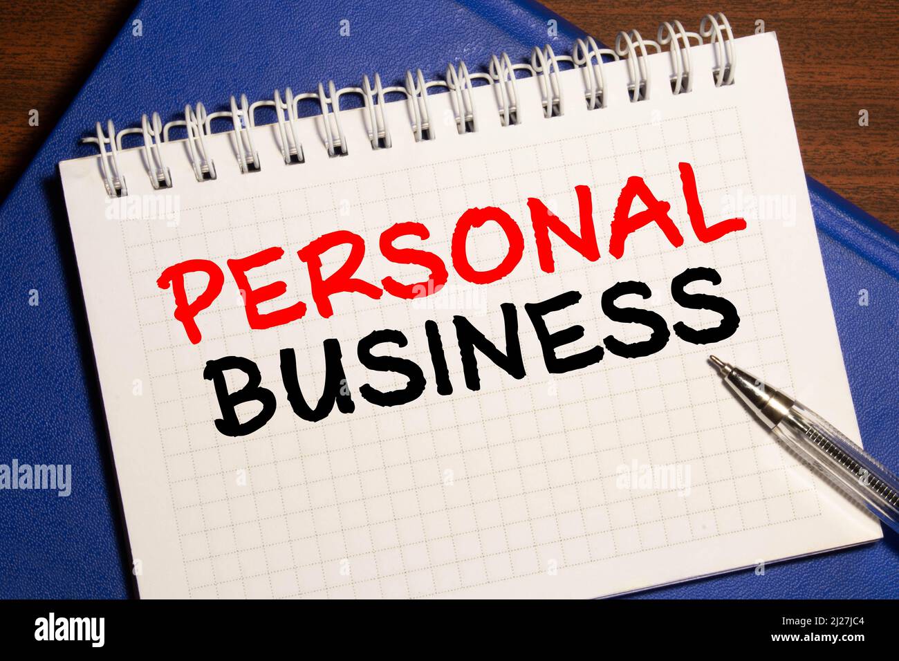Notepad with text PERSONAL BUSINESS, on business charts and pen and ...