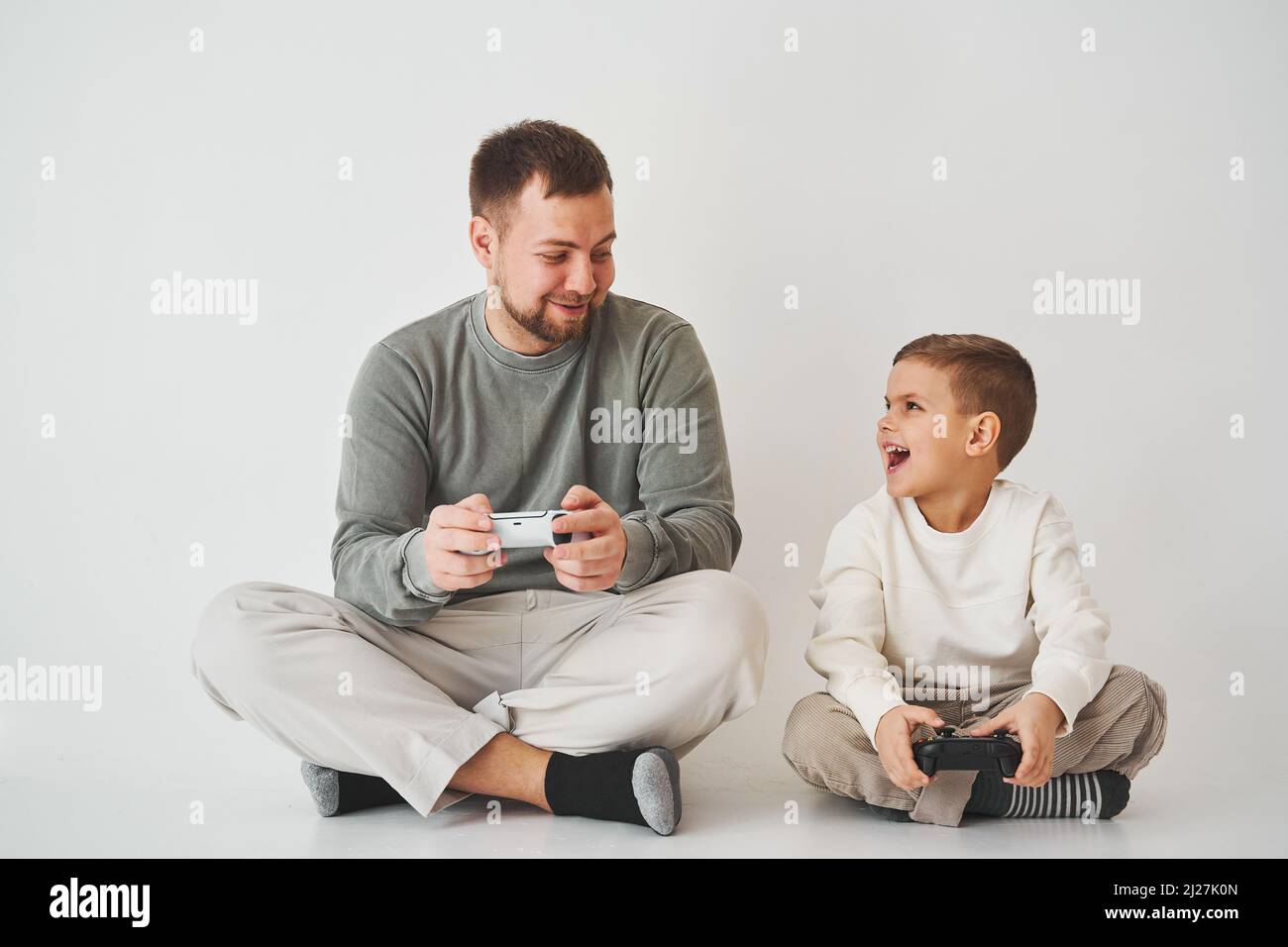Emotional family playing console games on a white background. Father ...