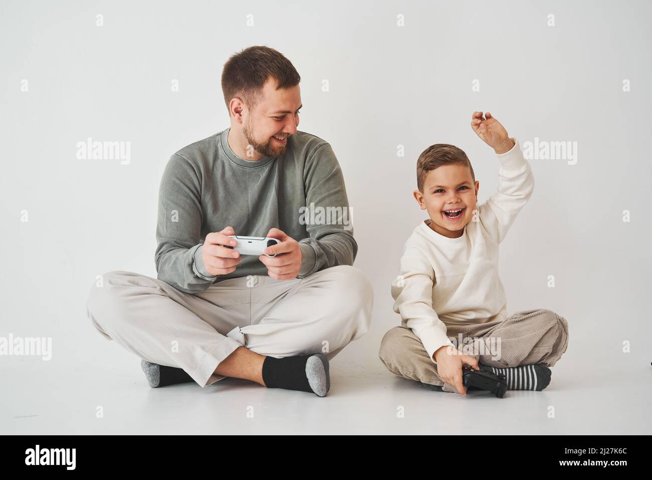Paternity. Father and son play gamepad console game laugh and have fun ...