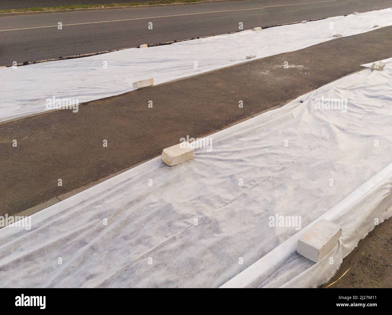 Lawns along the road, covered with covering material Stock Photo - Alamy