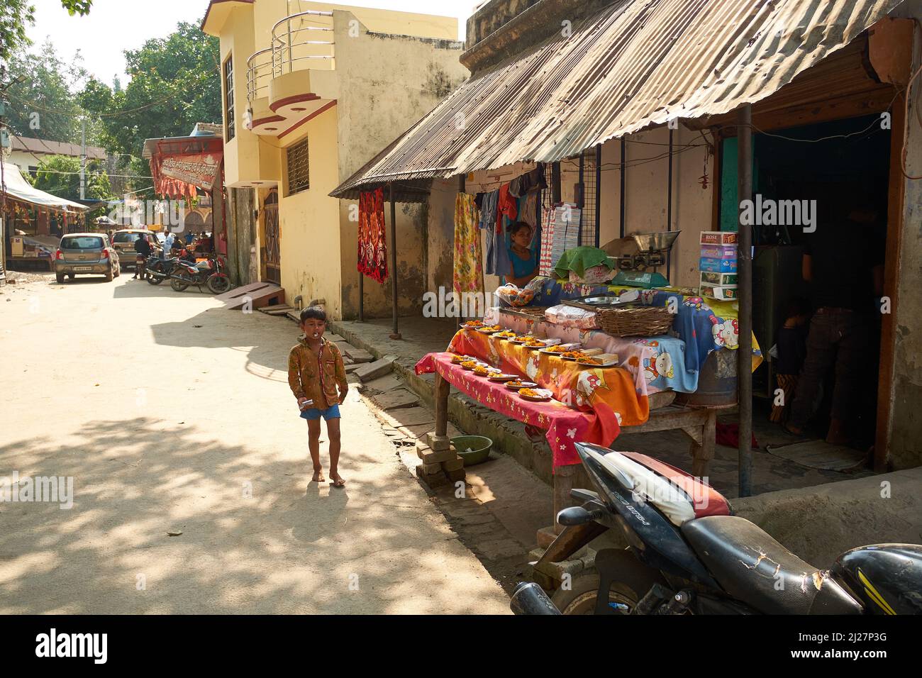 A little boy child runs playfully along the bazaar lanes of small town ...