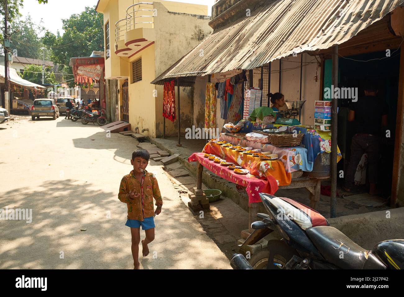 A little boy child runs playfully along the bazaar lanes of small town ...