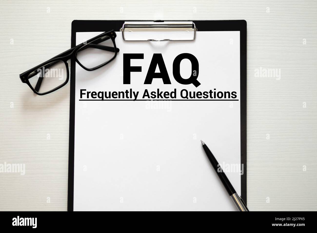 FAQ frequently asked questions text on on white paper Stock Photo - Alamy