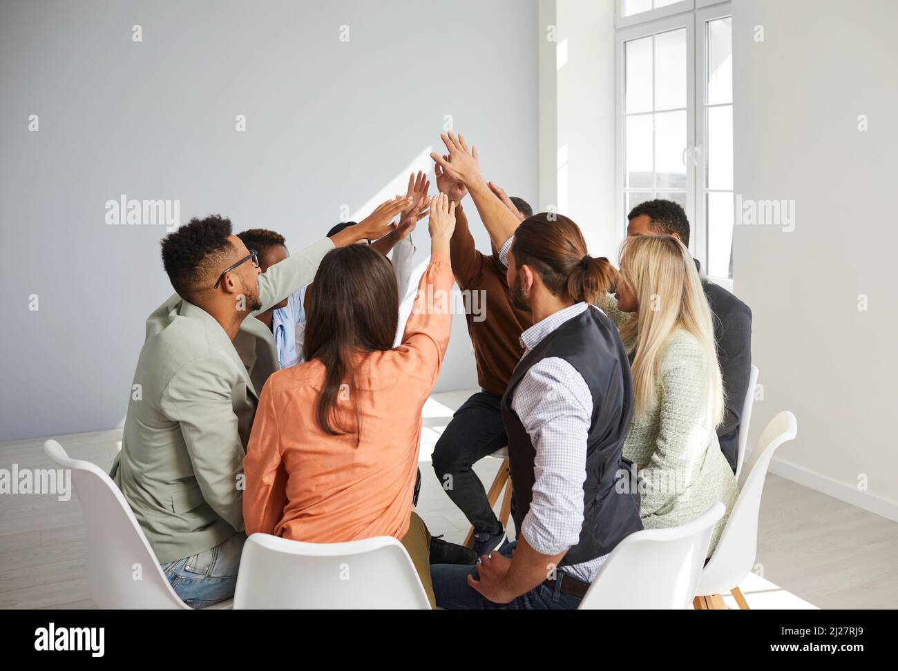 Diverse people join hands engaged in team training Stock Photo - Alamy