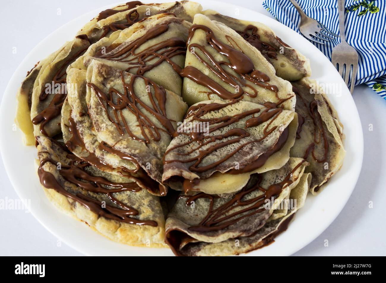 Crepes folded into a triangular shape covered with chocolate inside a ...