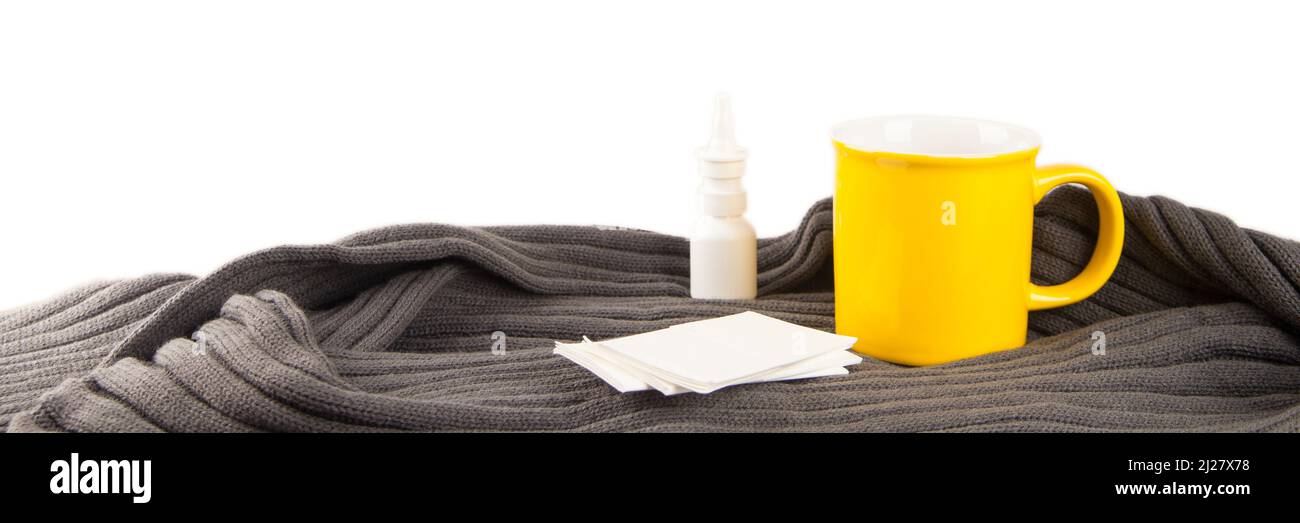 A yellow mug and nasal spray on a gray scarf with some napkins Stock ...