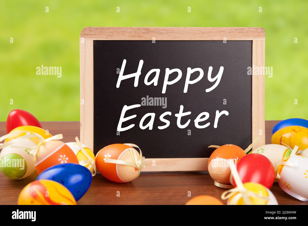 A closeup of a Happy Easter writing on a black board surrounded with ...