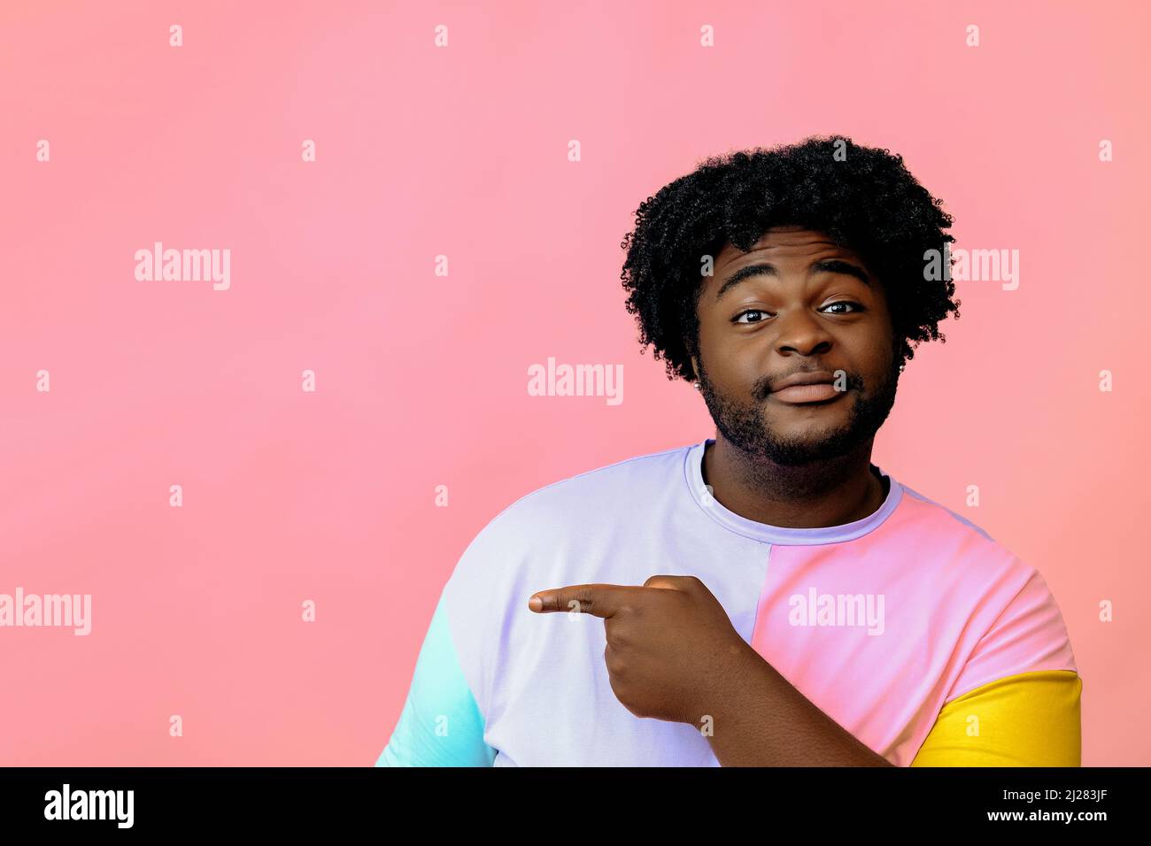 young african american man posing in the studio over pink background ...