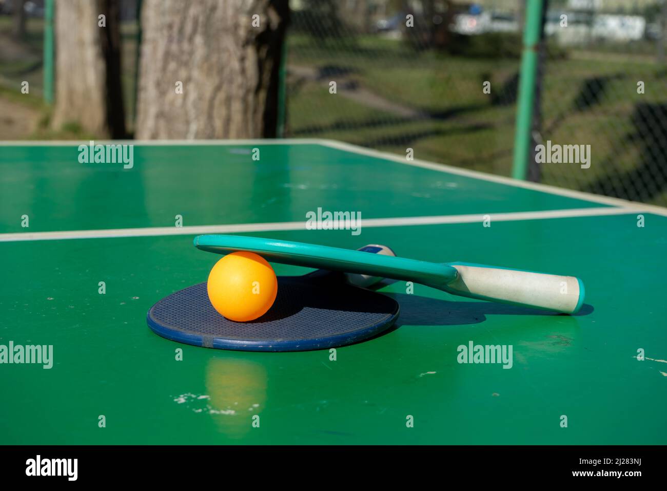 Two rackets and an orange ball on a green table. Ping-pong. Table ...