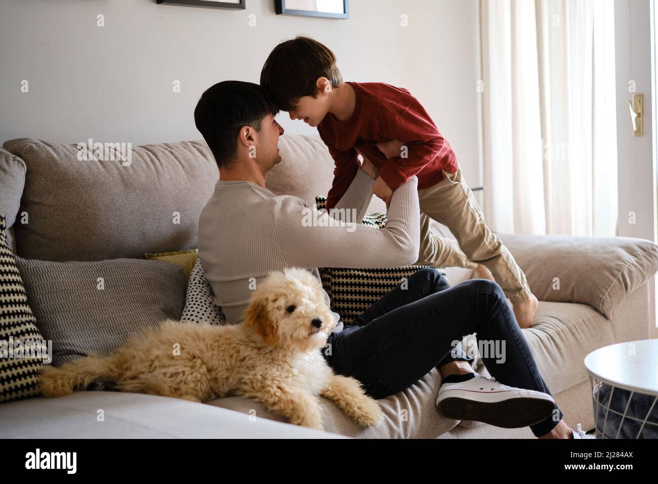 Father and son having fun together while relaxing at home with their ...