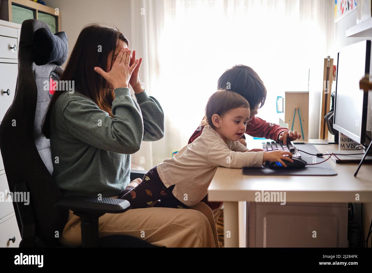 Stressed woman trying to work remotely from home with her kids Stock ...