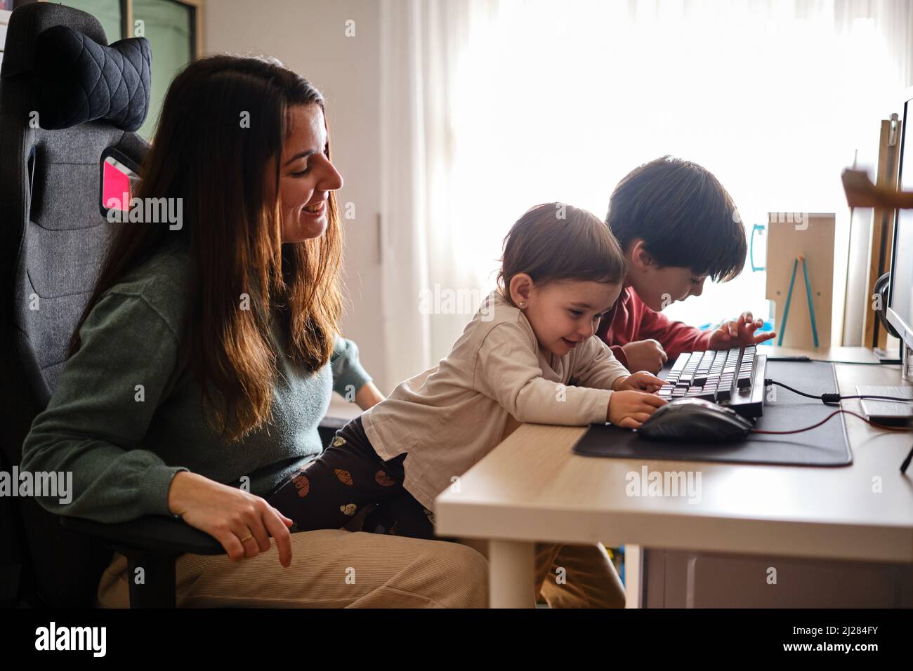 Mother working from home with her little kids Stock Photo - Alamy