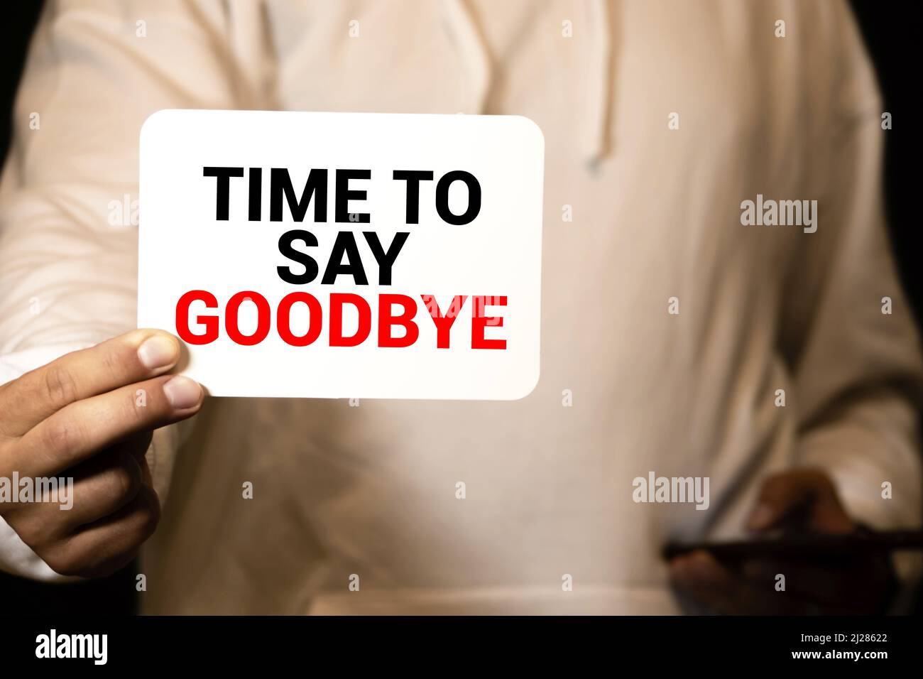 Closeup on businessman holding a card with text TIME TO SAY GOODBYE ...
